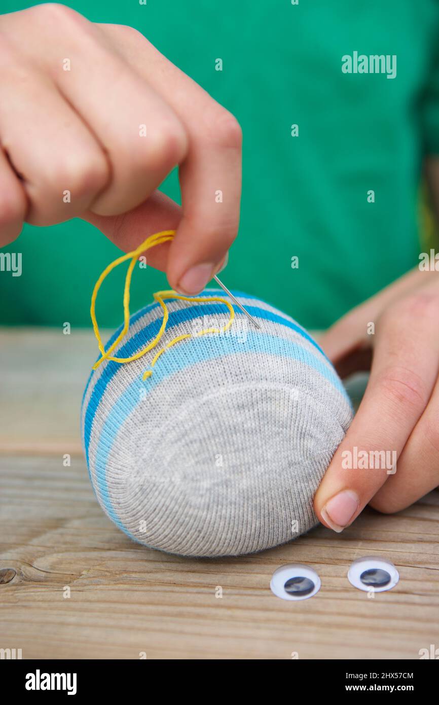 Child handcrafting lavender bag using needle and thread Stock Photo - Alamy
