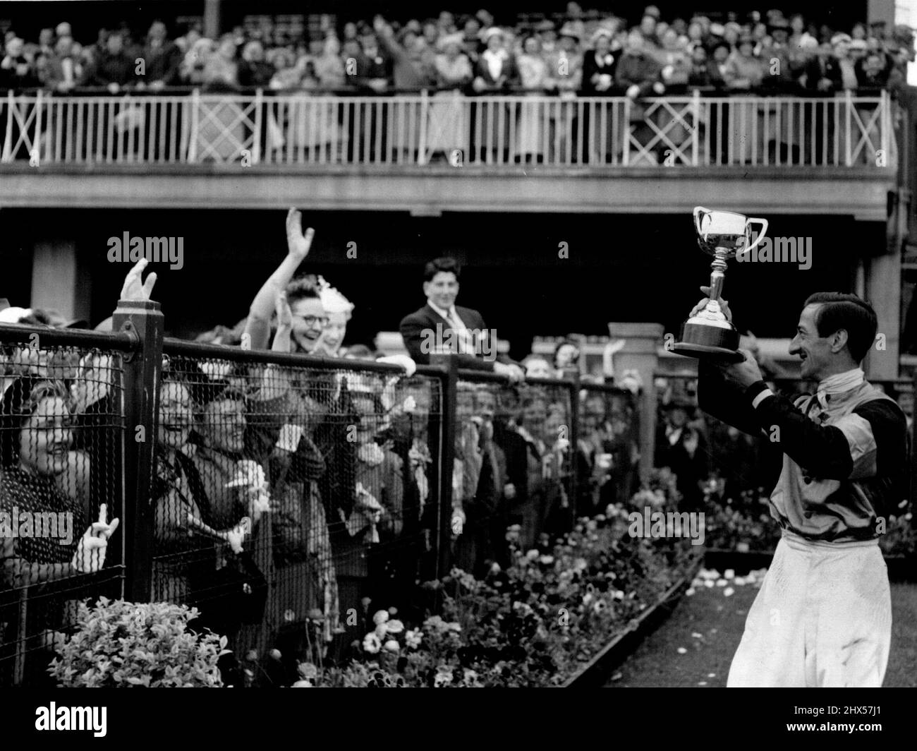 Jack Purtell holds aloft the 1954 Melbourne Cup which he won on Rising ...
