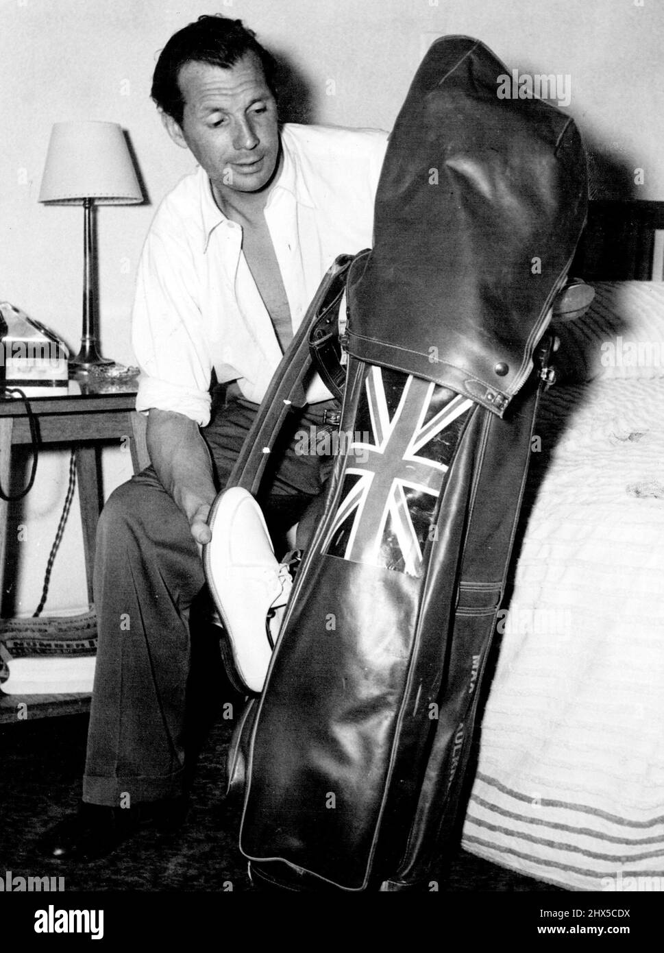 Max Faulkner, British golfer, unfacing from his giant bag in usher's ...