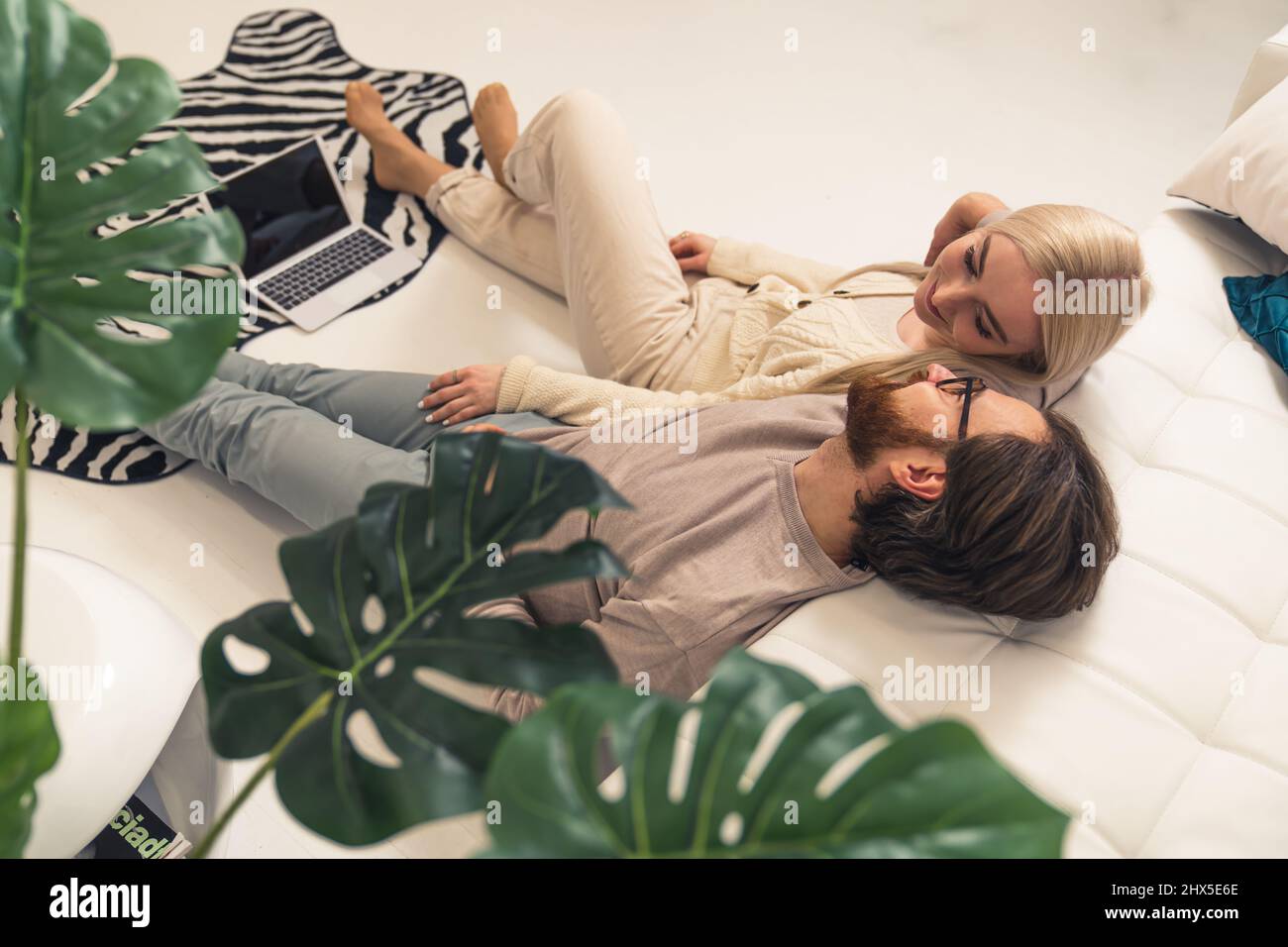 two caucasian people in a relationship laying down, looking at each ...