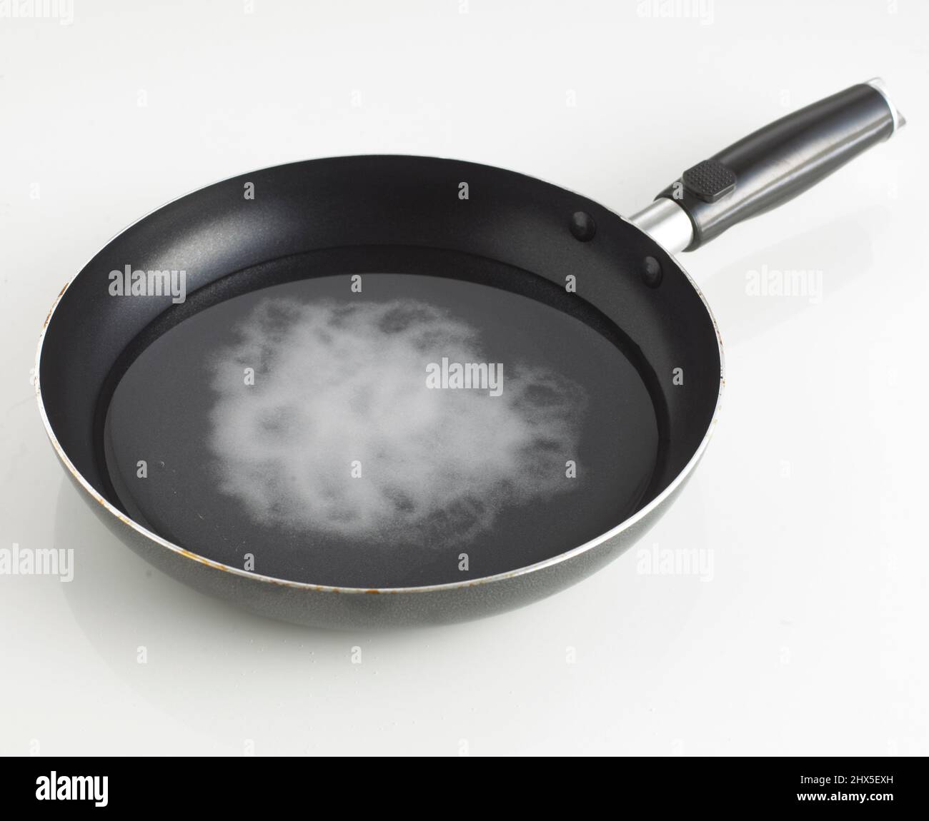 Salt and water in frying pan, close-up Stock Photo - Alamy