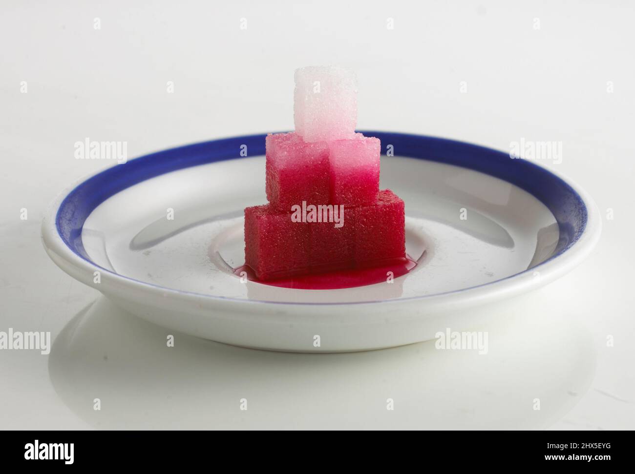 Capillary action experiment using sugar crystal and red liquid, close ...