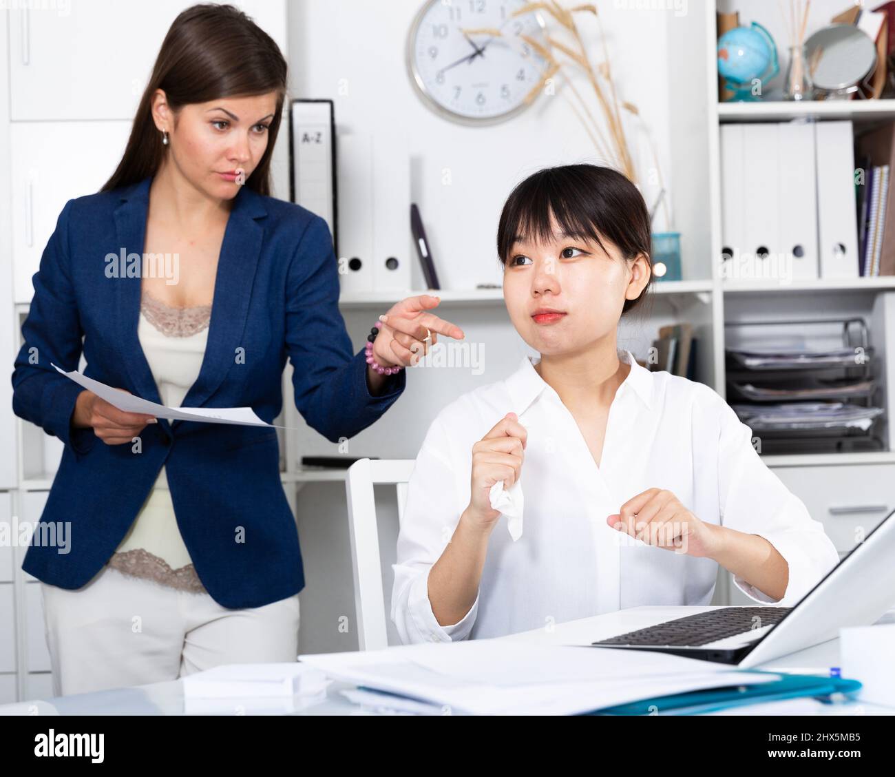 Upset asian woman with angry boss Stock Photo - Alamy