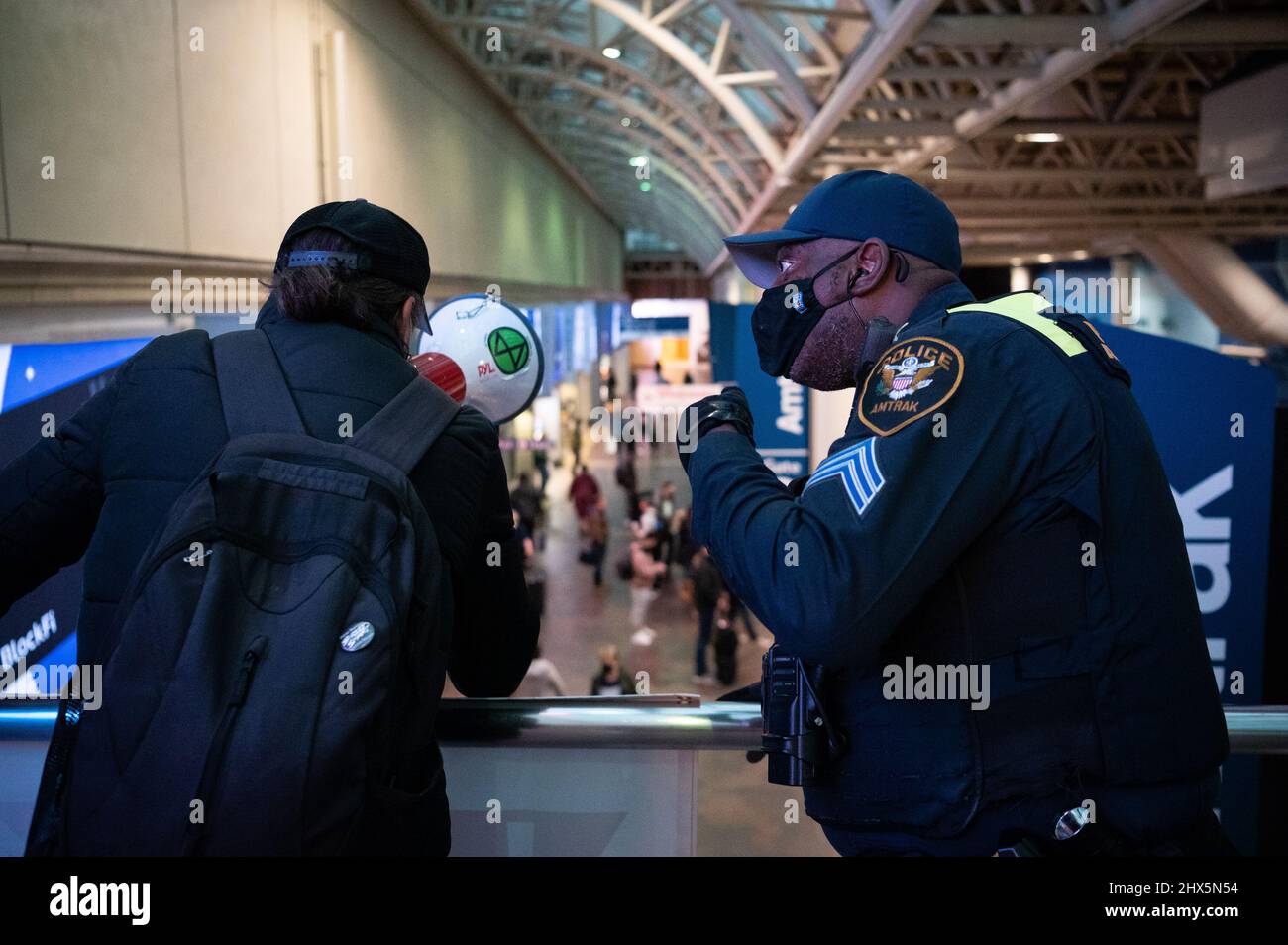 An Amtrak Police Officer orders a climate demonstrator to stop during a ...