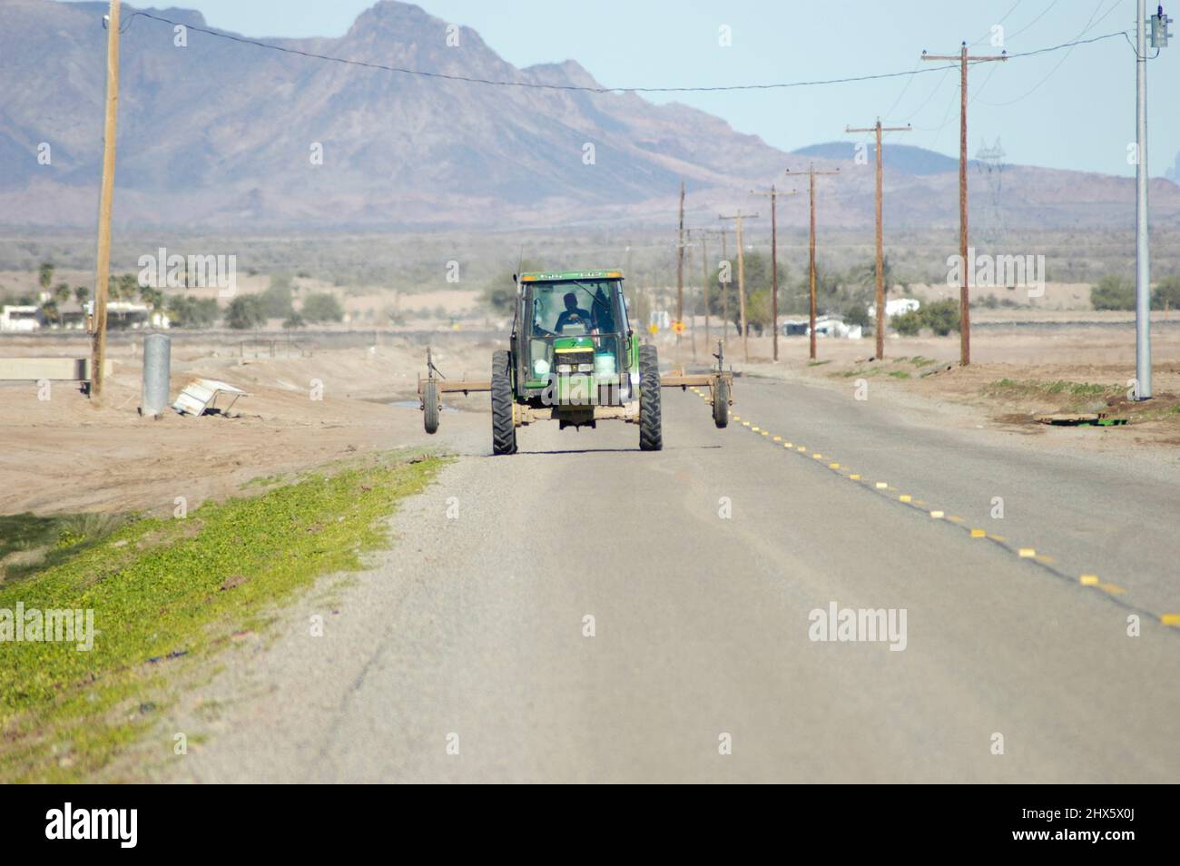 Farm tractors passing on farm road Stock Photo - Alamy