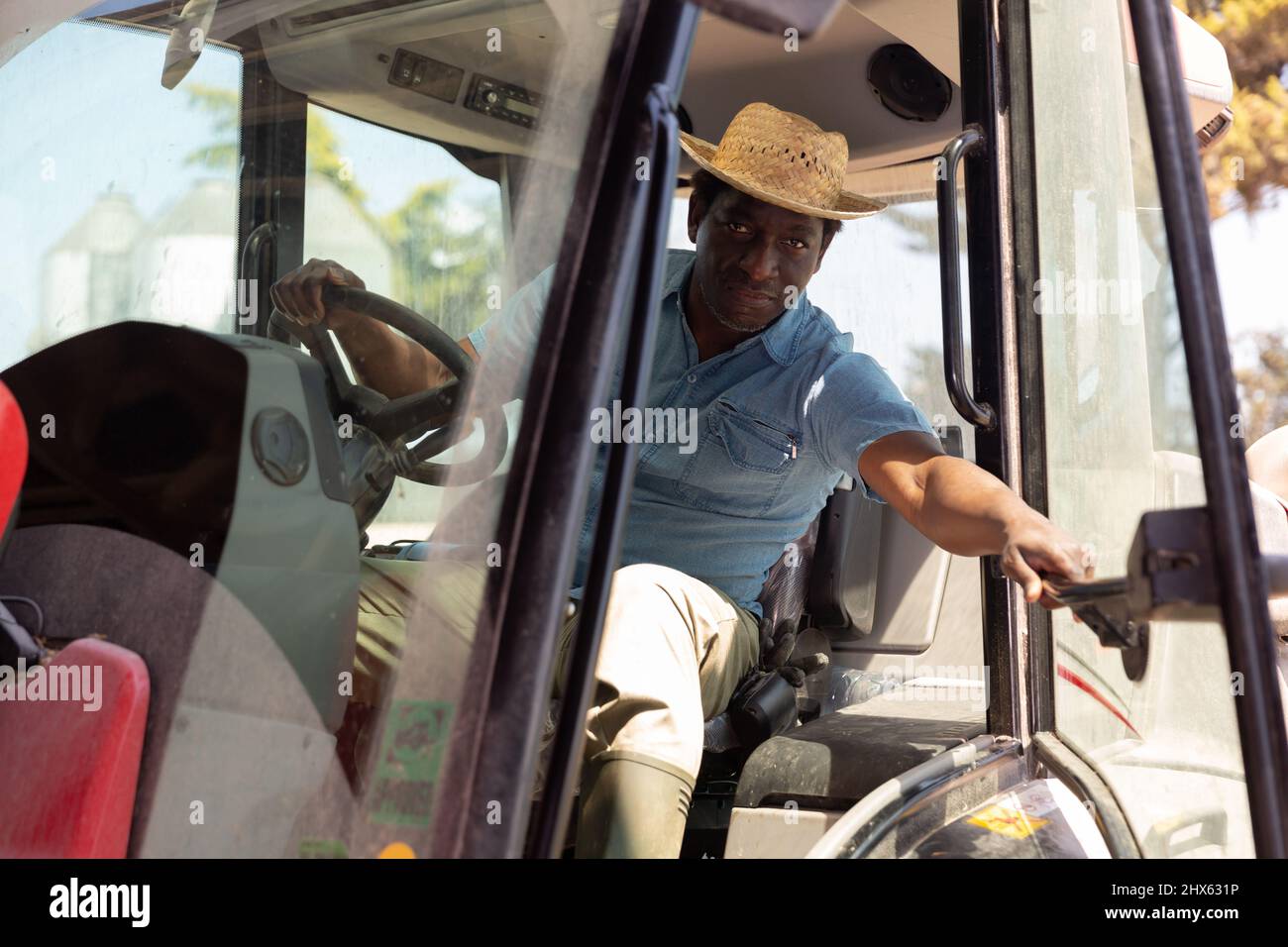 Man driving farm tractor during spring works on cowshed Stock Photo - Alamy