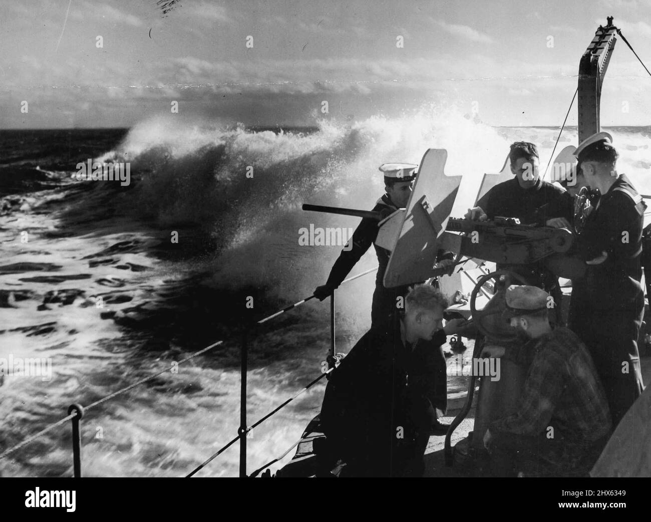 Members of the crew around an ***** anti-aircraft gun on H.M.A.S. Nepal ...