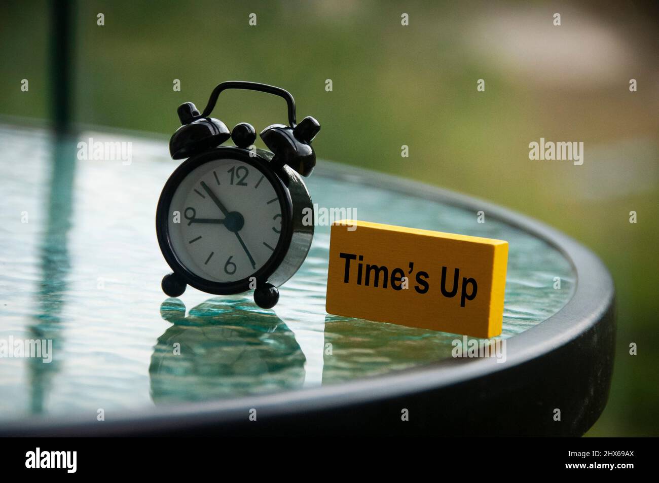 Time is up text on yellow wooden block with alarm clock background ...