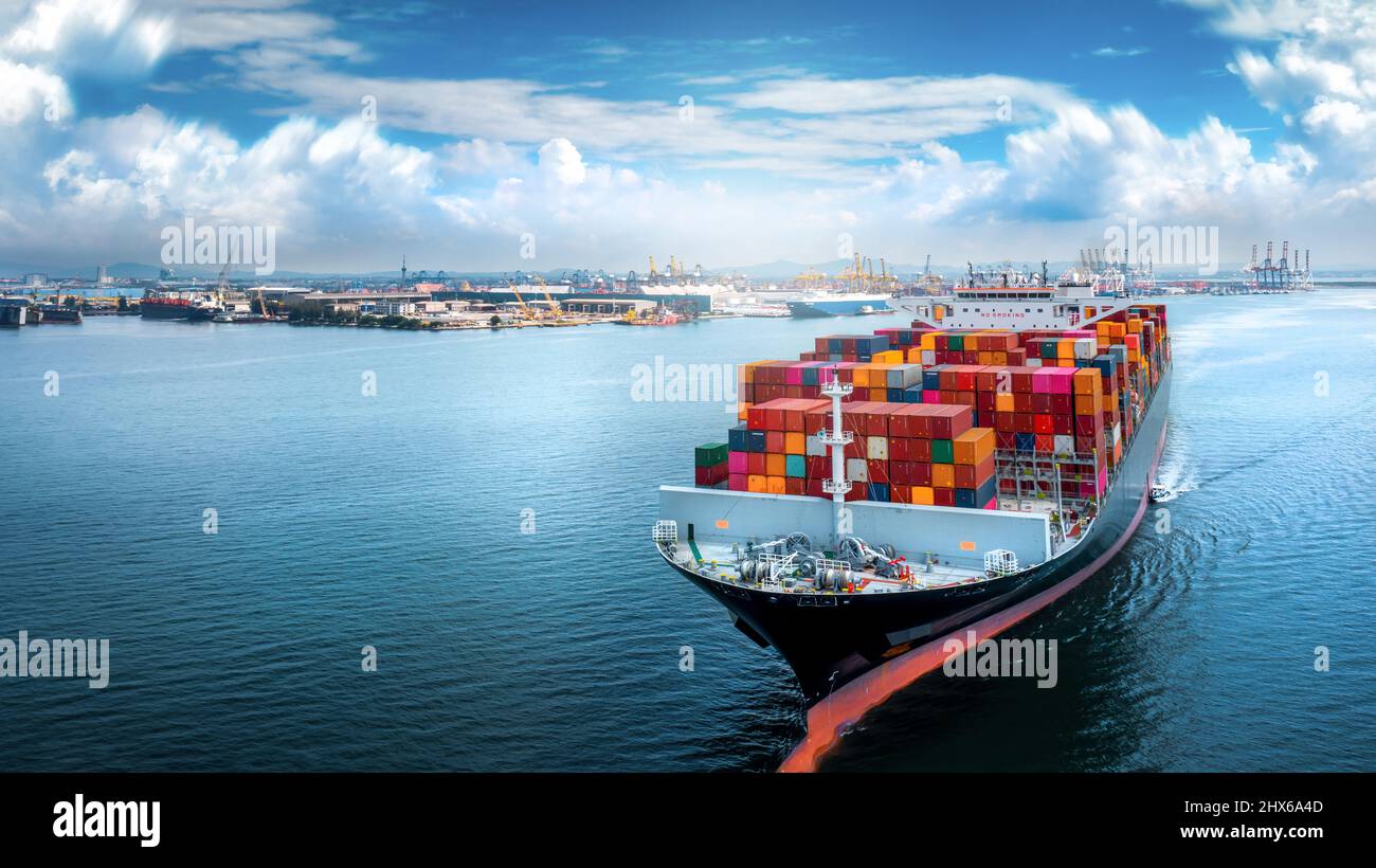 Aerial side view of cargo ship carrying container and running for ...