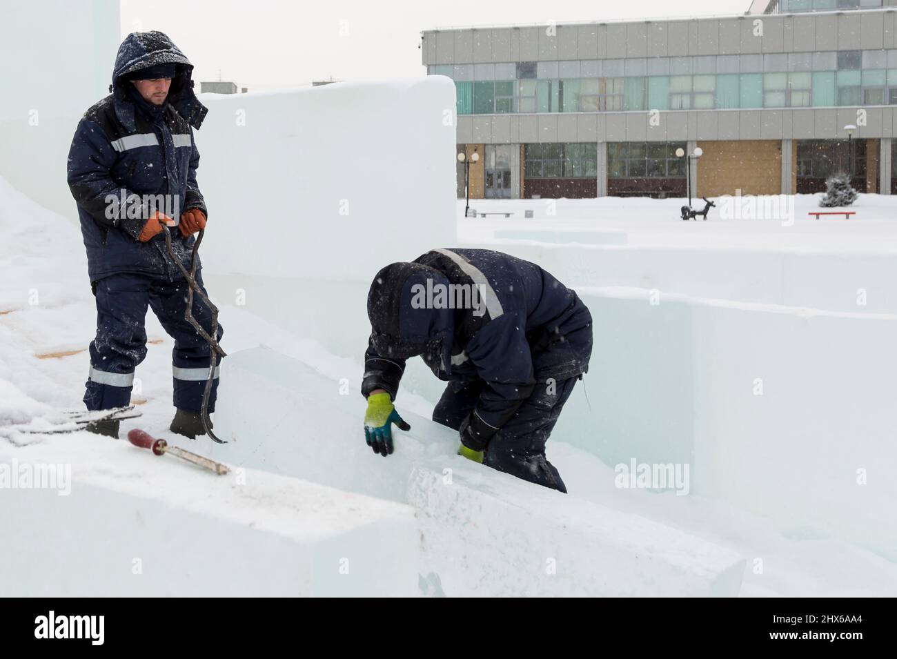 The worker pulls the ice block around the ice camp assembly site with ...