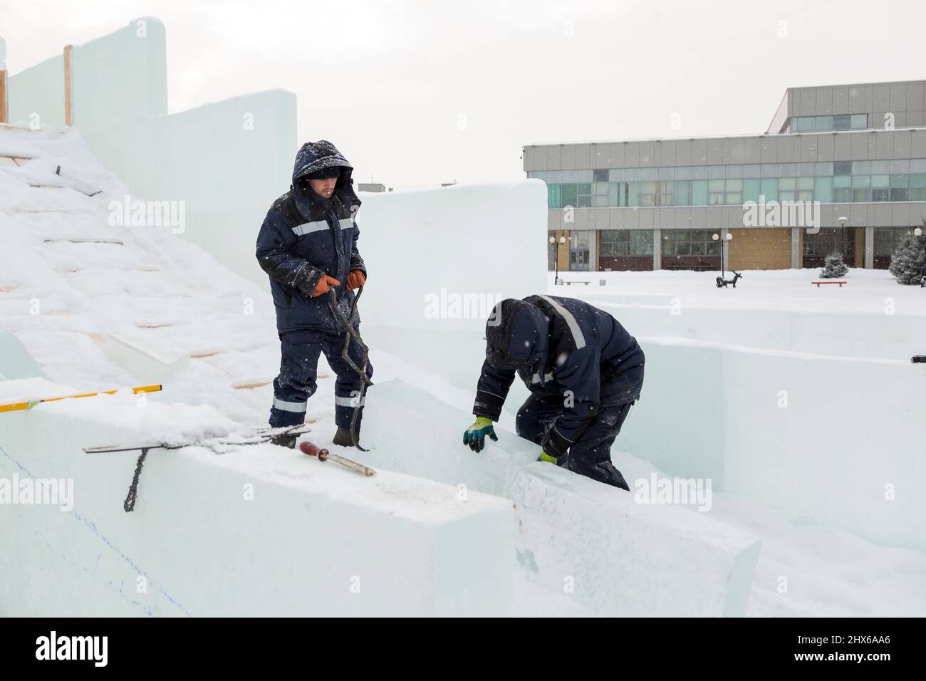 The worker pulls the ice block around the ice camp assembly site with ...