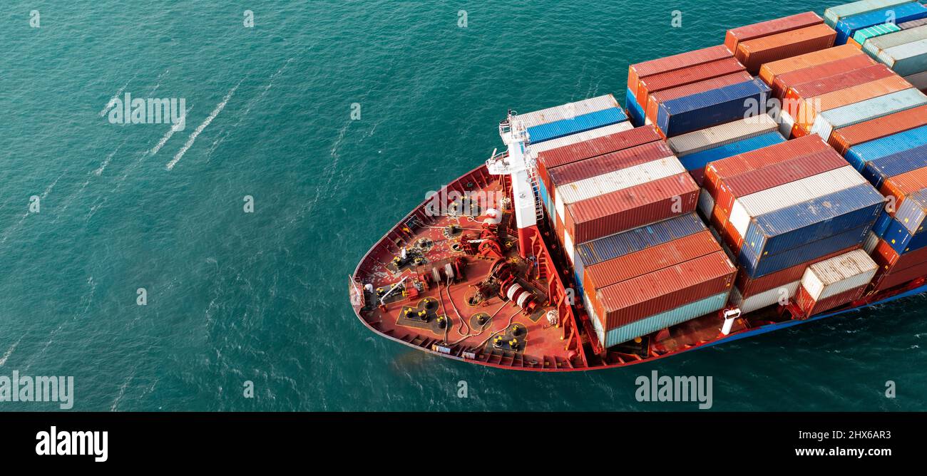 Aerial side view of cargo ship carrying container and running for ...
