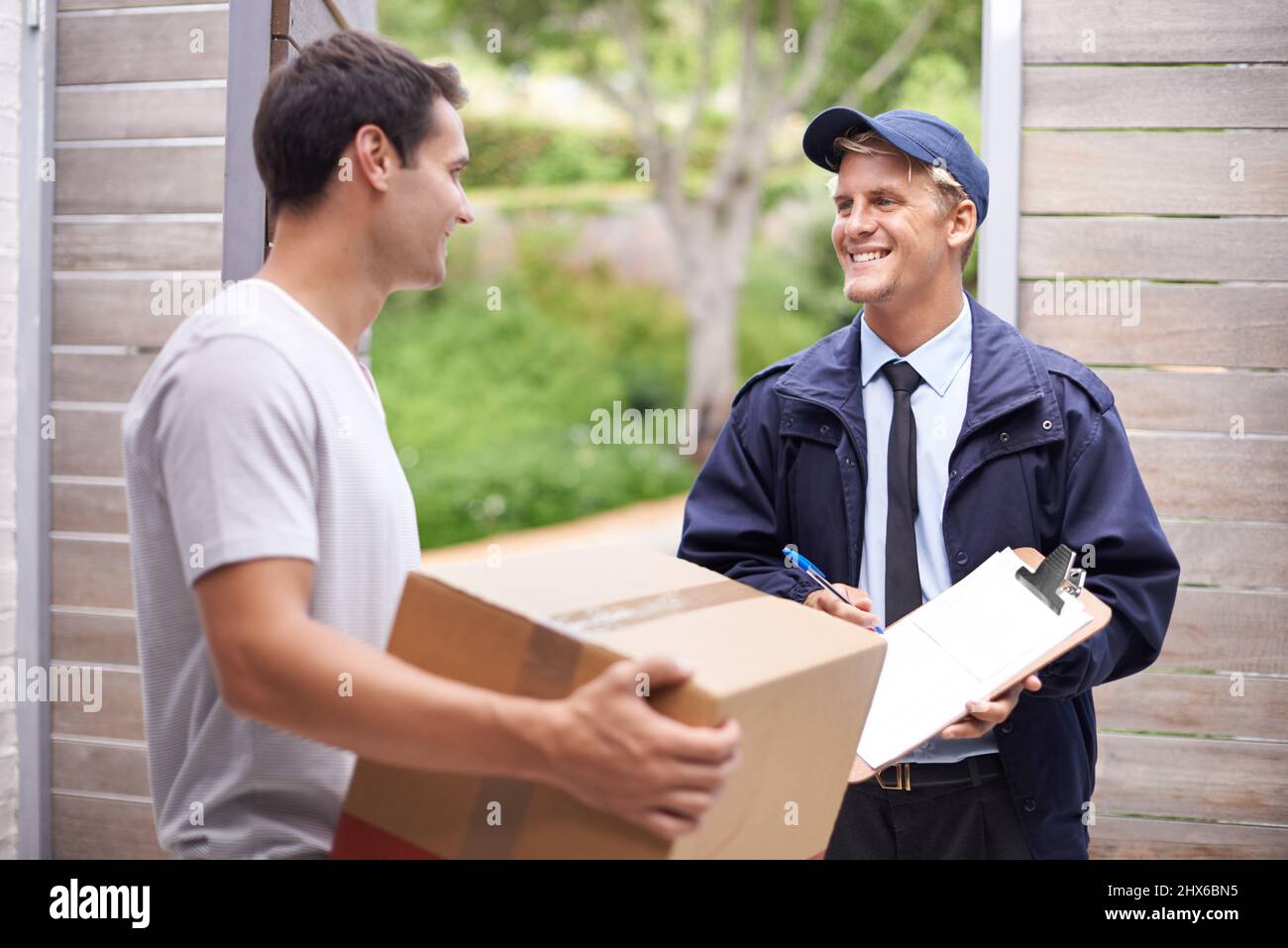 My parcel finally came. Shot of a young man receiving a parcel from the ...