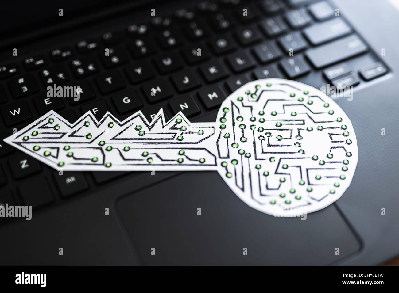 encryption key icon made of circuits and LED lights on top of laptop ...