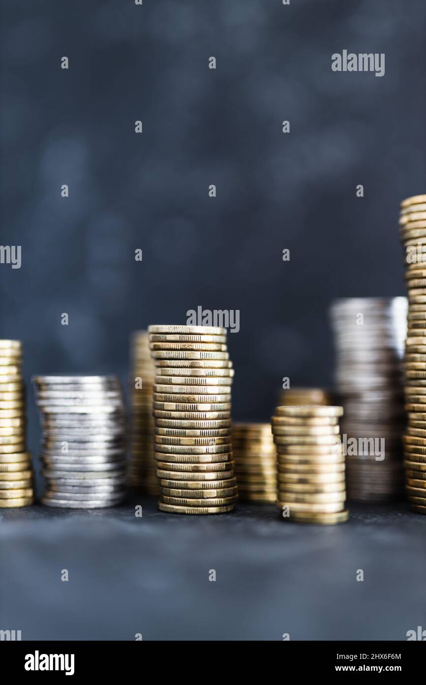 stacks of different golden and silver coins creating a big amount of ...