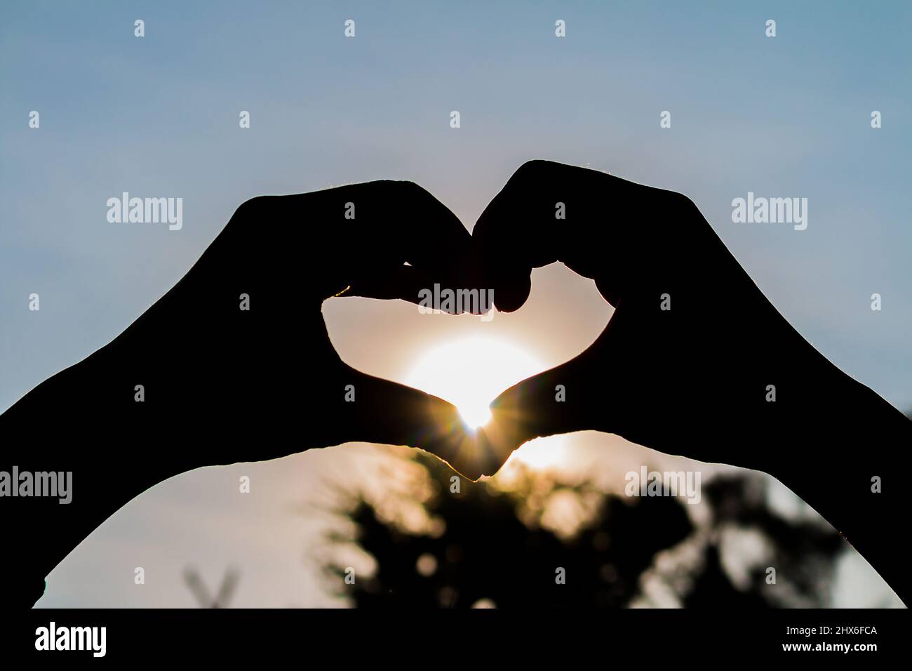 love shape hand silhouette at sunset background Stock Photo - Alamy