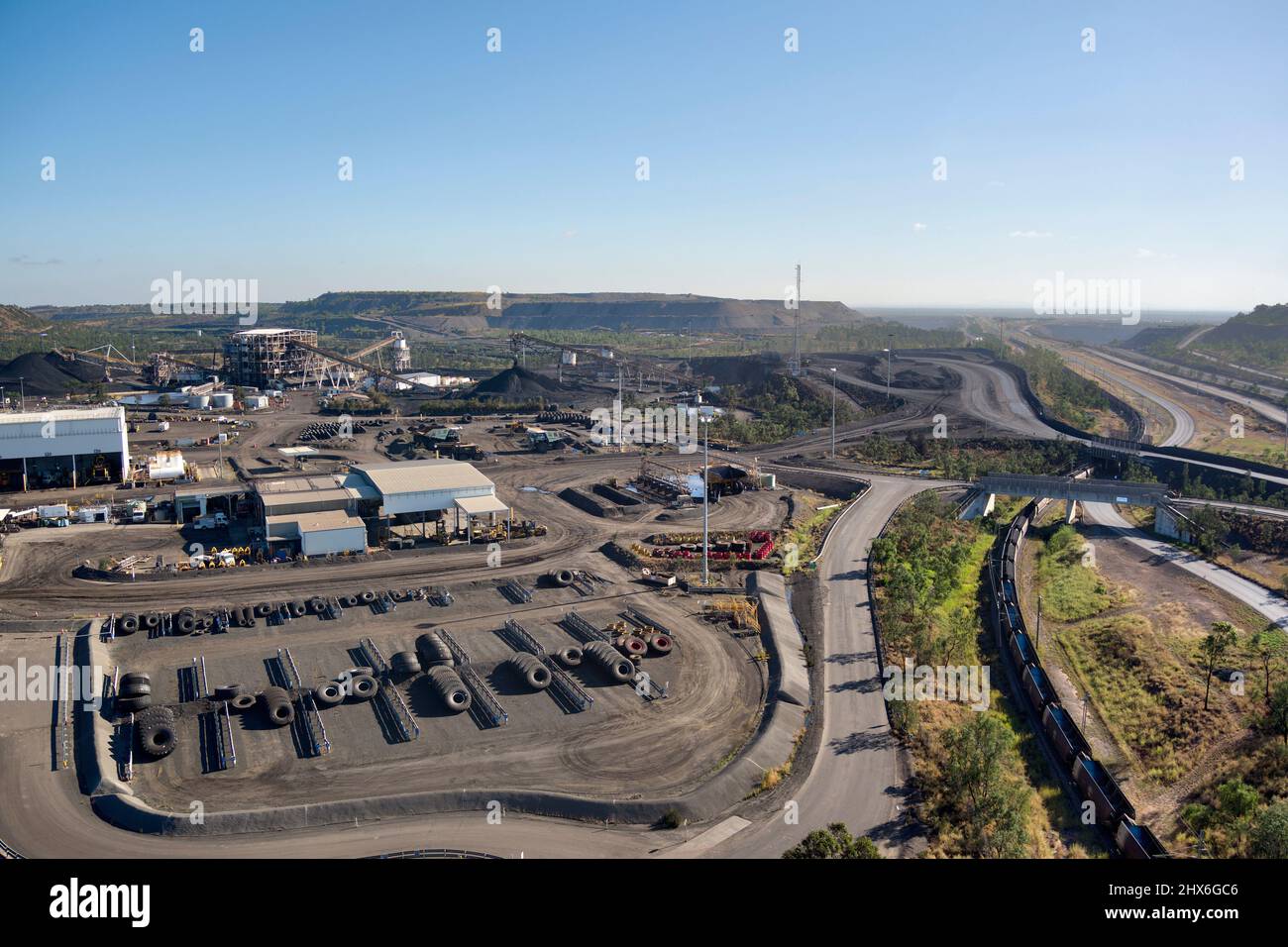 Aerial of coal train passing the open cut Peak Downs coal mine near ...