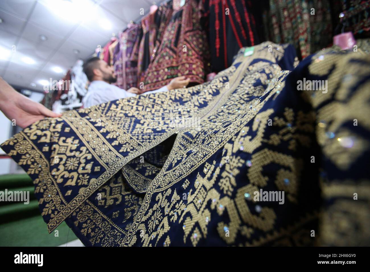 A Palestinian man arranges and displays many of Palestinian traditional ...