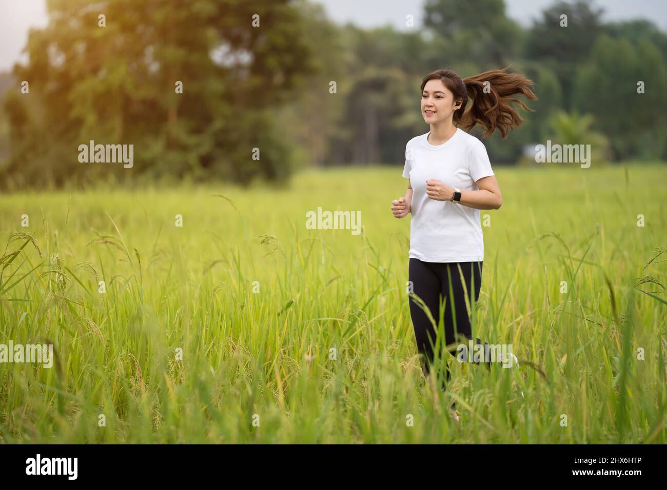 young woman running on wooden path in field Stock Photo - Alamy