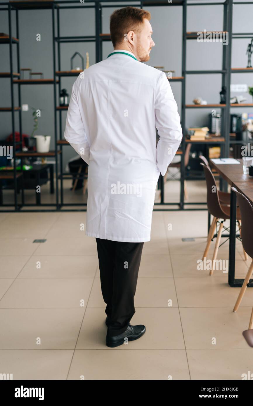 Back view of unrecognizable young adult male doctor in white medical ...
