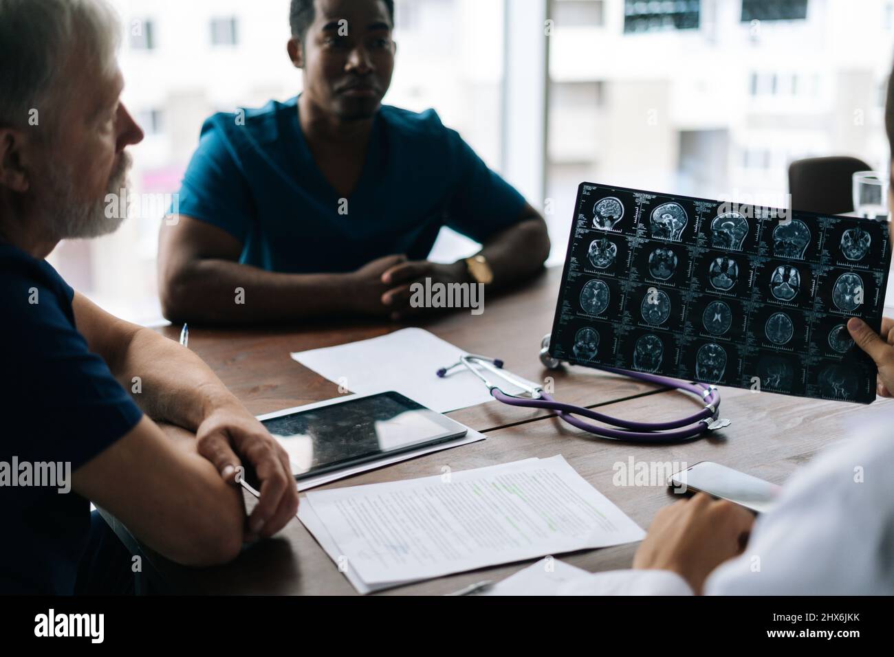 Close-up working of team multi-ethnic doctors discussing together ...