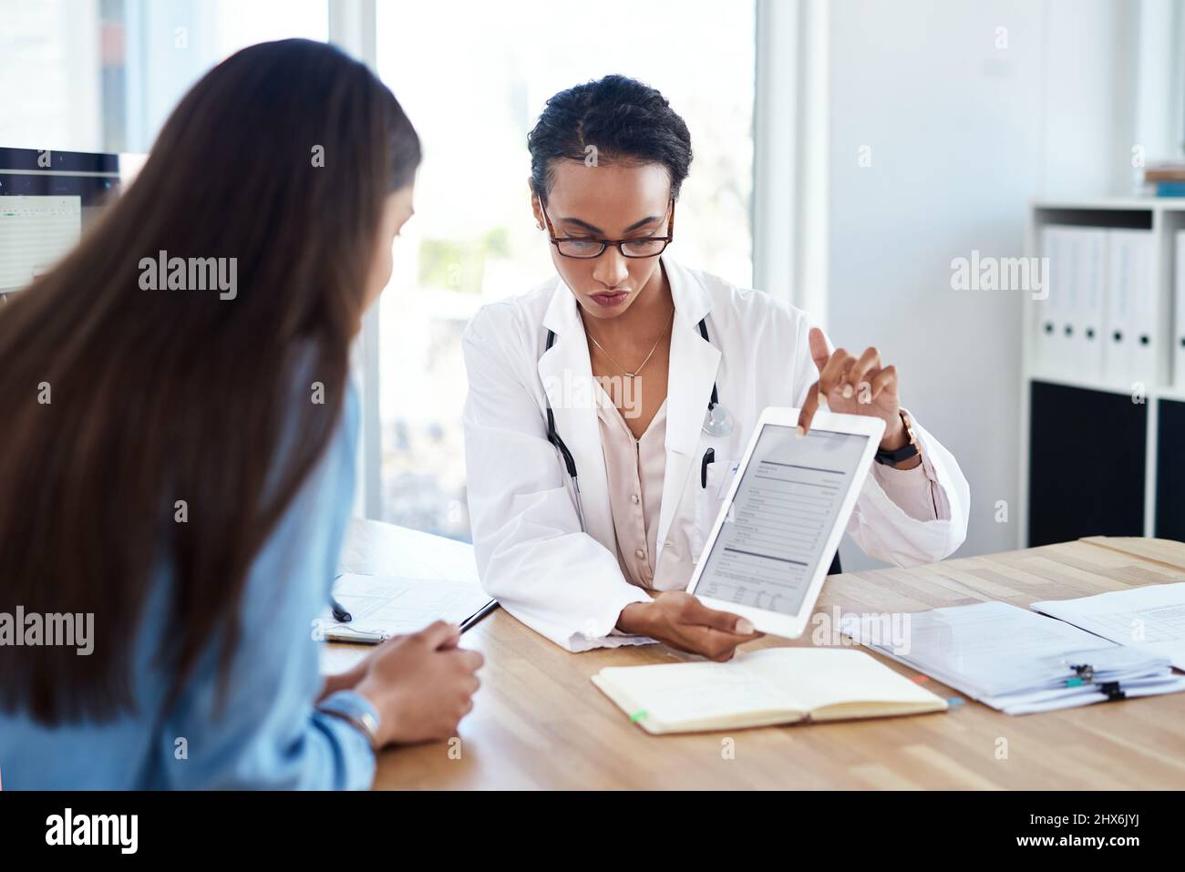 Less paper, more patient feedback. Shot of a young doctor using a ...