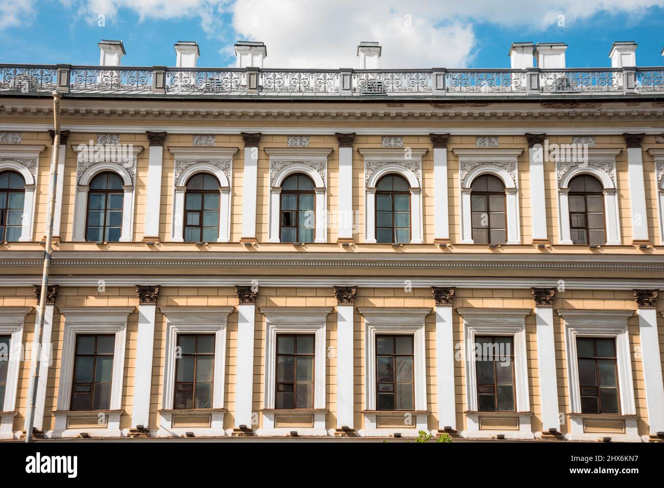 Hotel facade yellow-orange building with window arches Stock Photo - Alamy