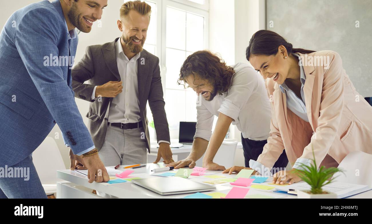 Team of happy business people laughing at something funny while ...