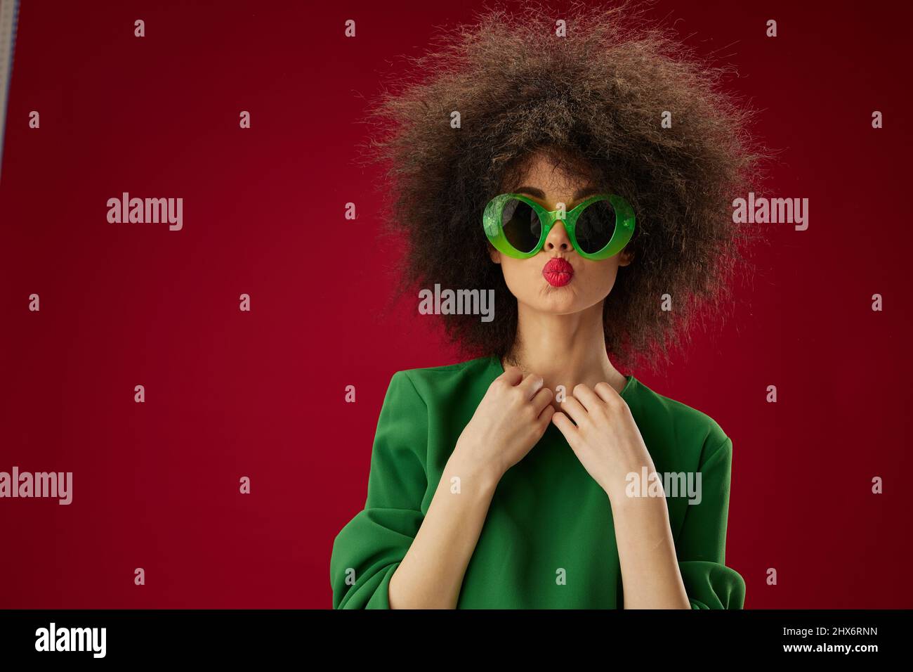 pretty woman in green afro dress hairstyle red background Stock Photo ...