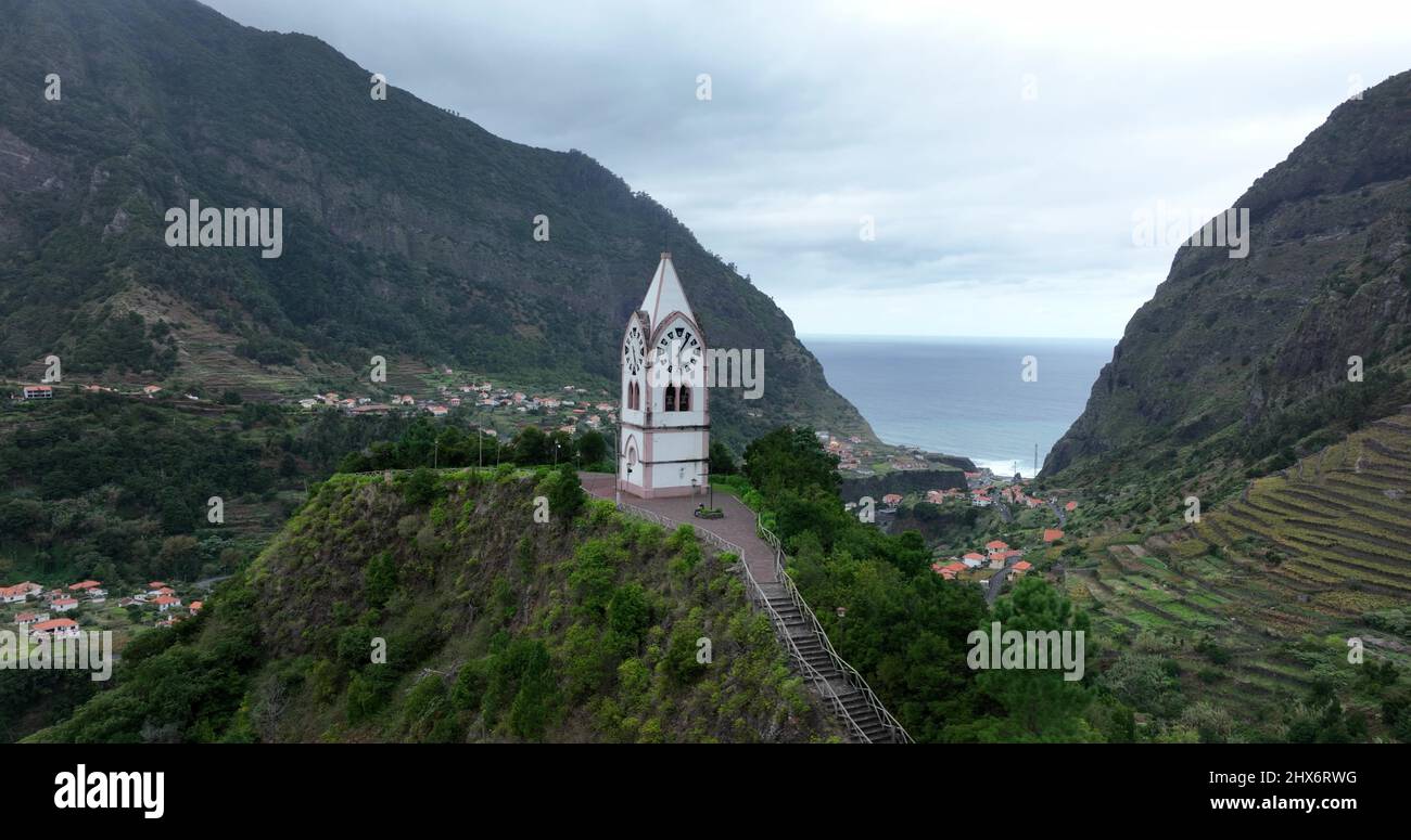 Small church surrounded by cliffs and mountains and a village in a ...