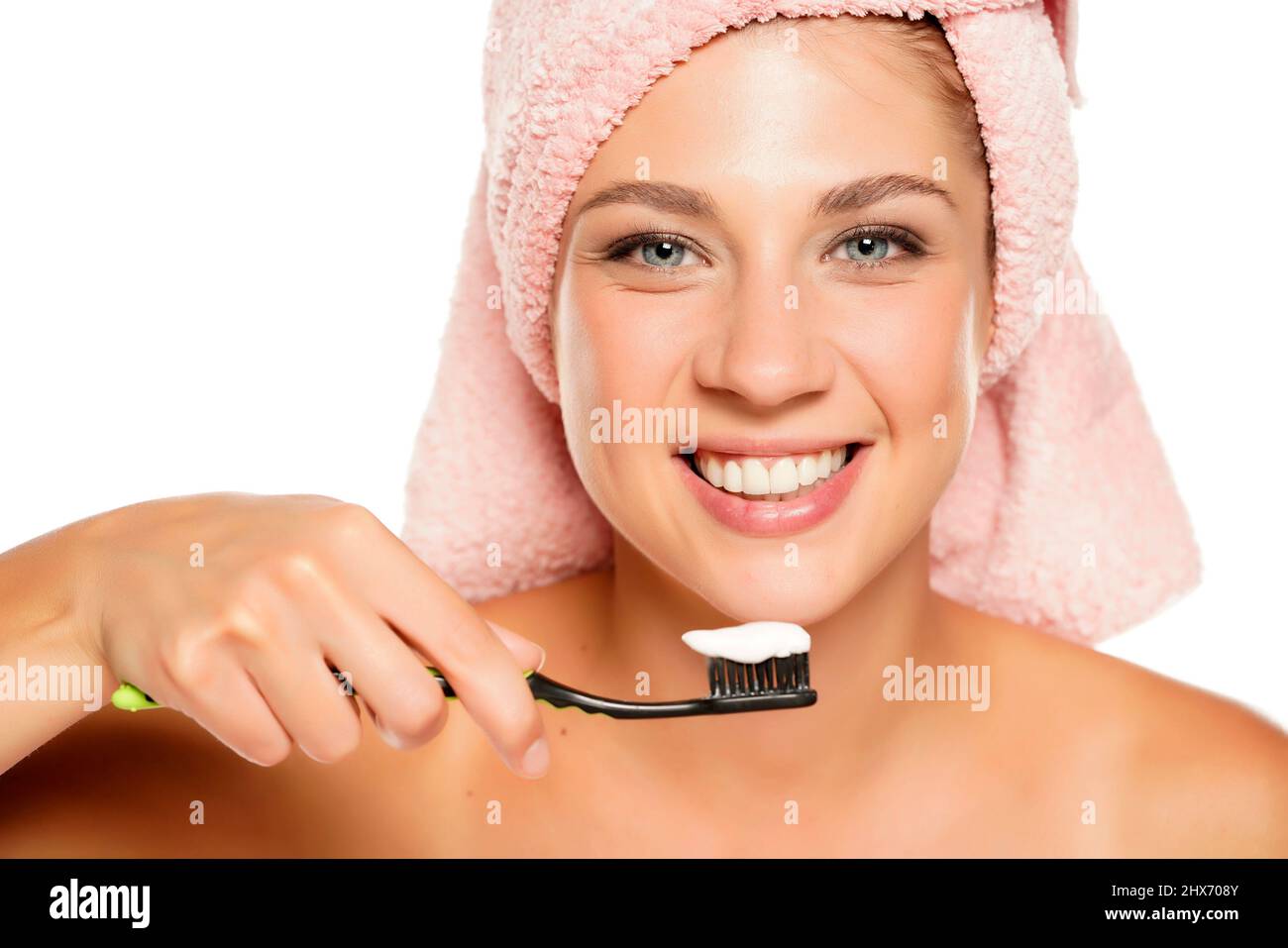 a young beautiful smiling woman with blue eyes posing with a toothbrush ...