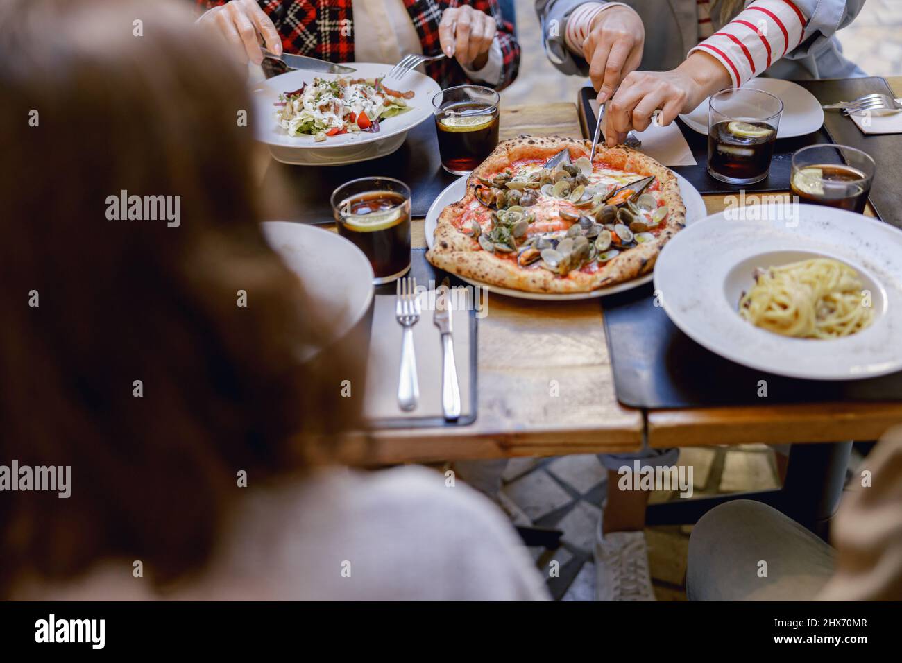 Friendly company enjoying delicious food in restaurant Stock Photo - Alamy