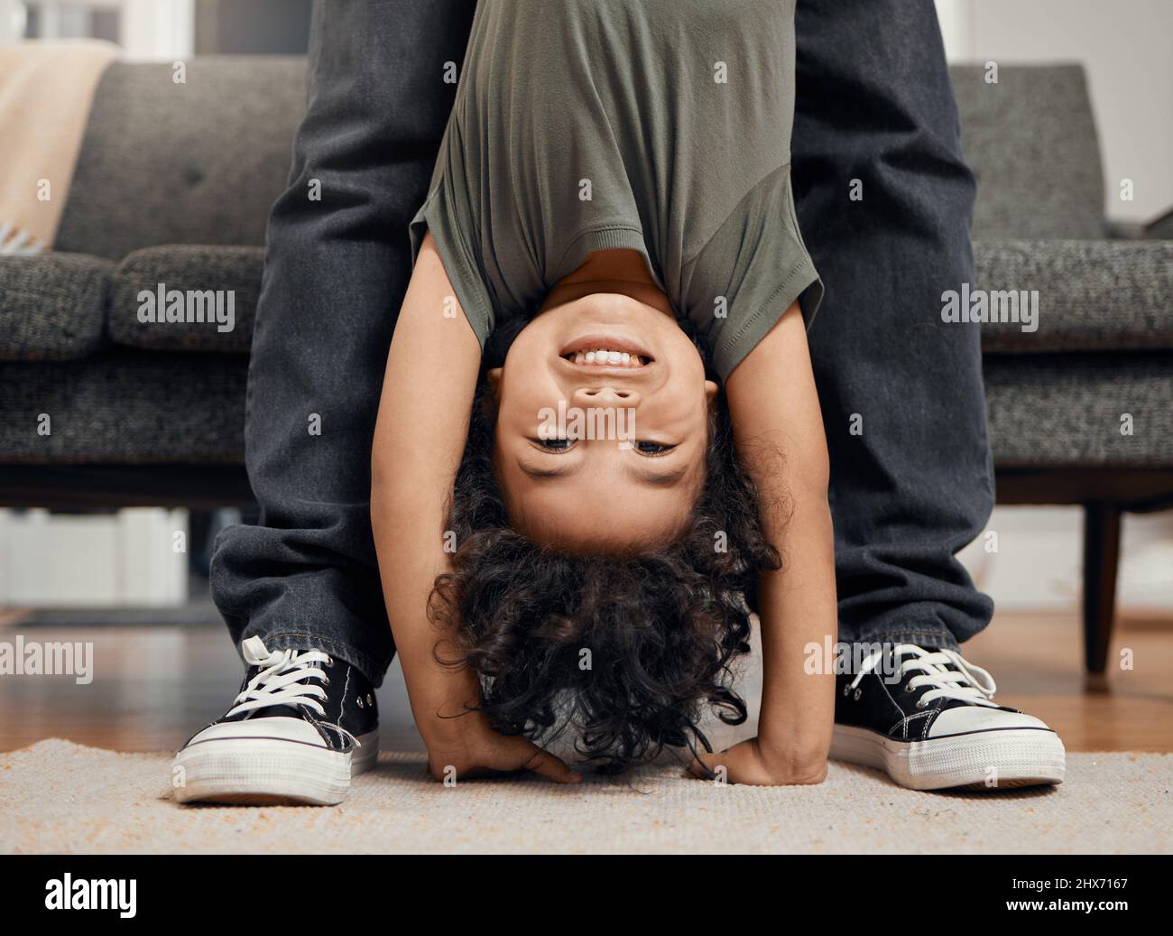 Everyone has a fun side. Shot of an adorable little boy being held upside down Stock Photo - Alamy