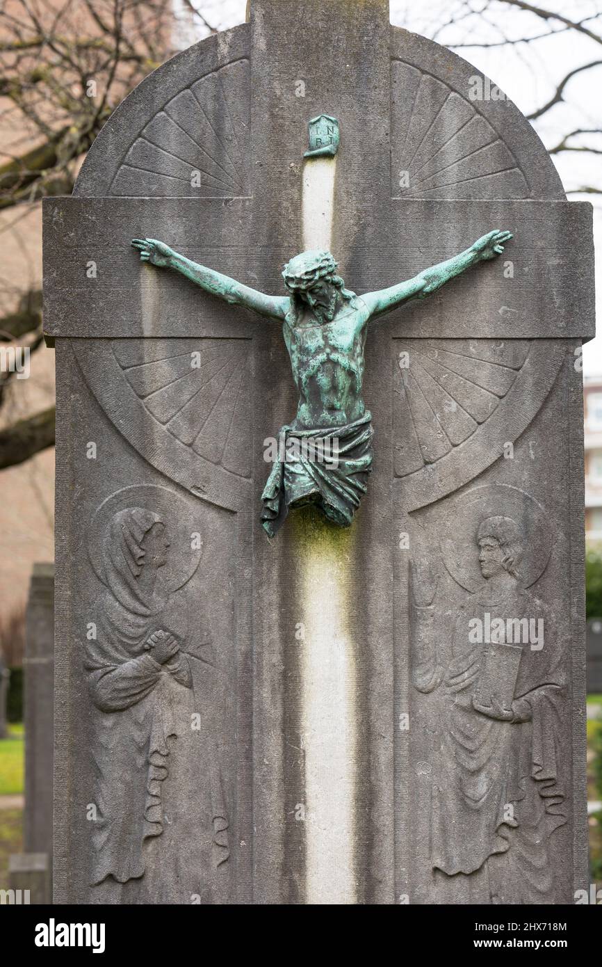 Crucifix with Jesus hanging without legs on a tombstone in the ...