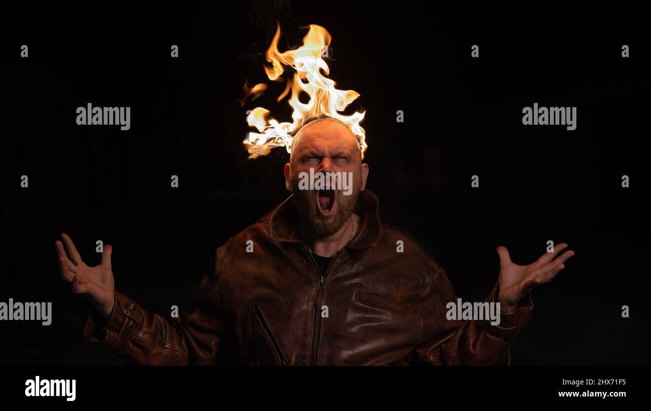 Bald man in a leather jacket with a burning head on a dark background ...