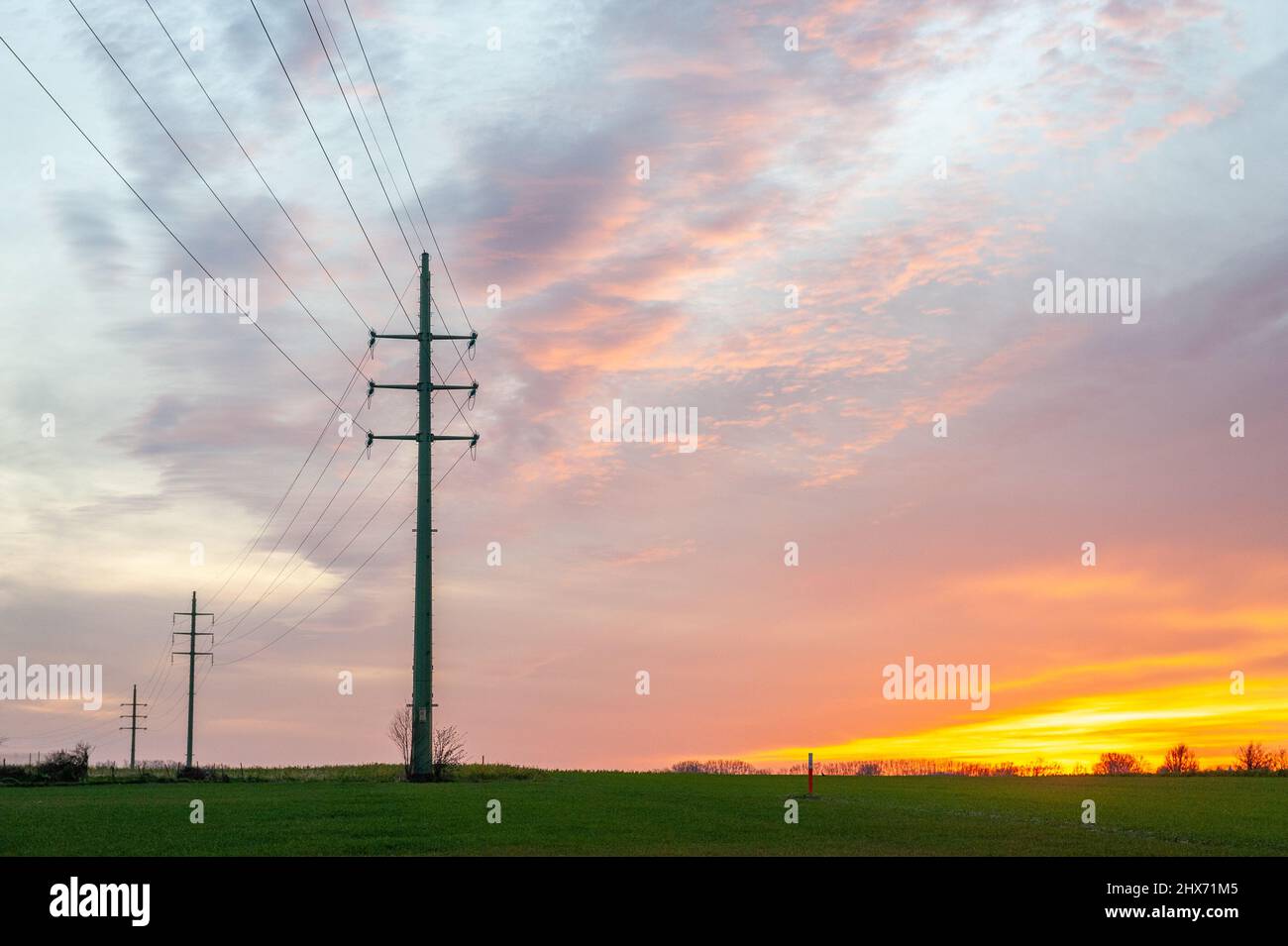 The setting sun in the flemish country side colors the sky intensely ...