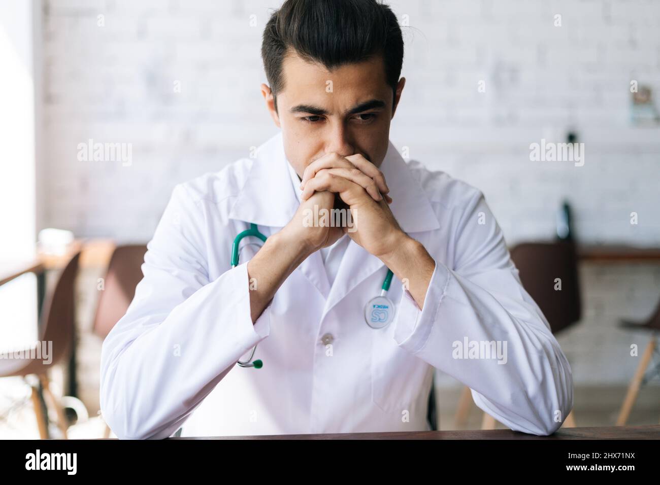 Portrait of thoughtful male physician therapist wearing white uniform ...