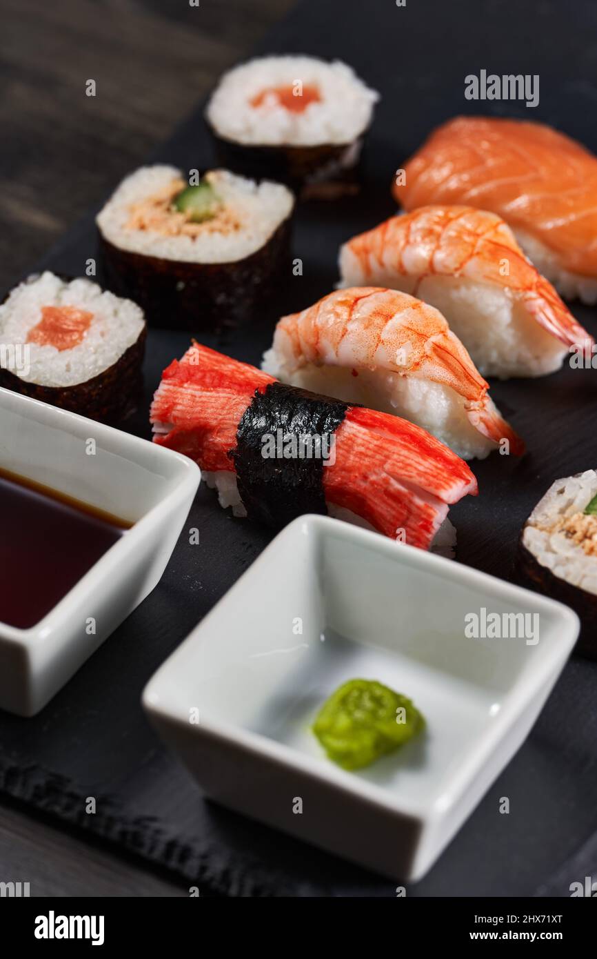 Sushi assortments served with soy and wasabi on a black stone Stock ...
