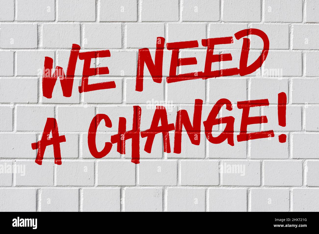 Graffiti on a brick wall - We need a change Stock Photo - Alamy