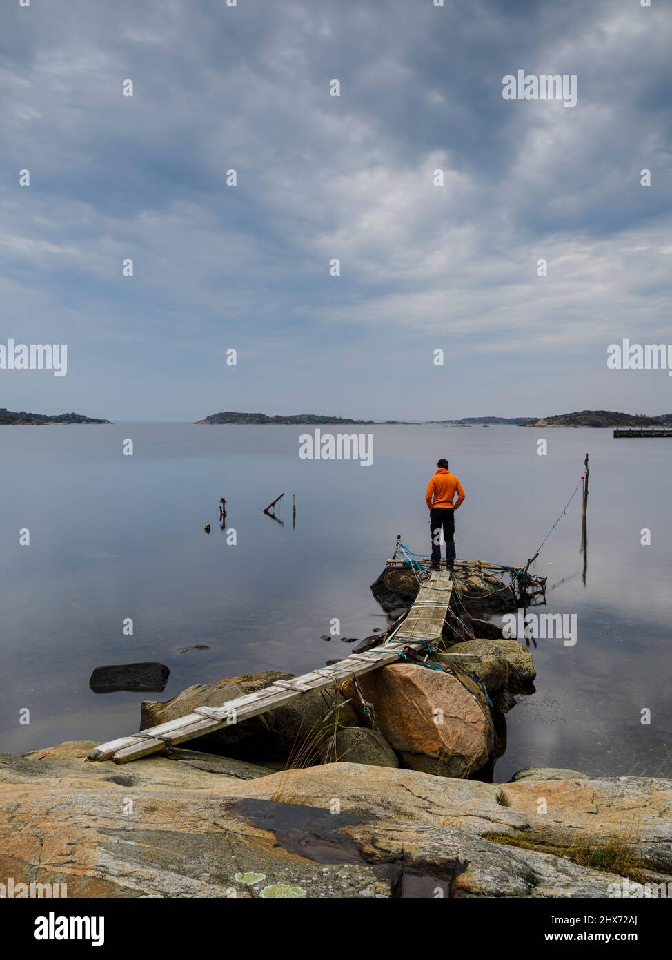 Man standing on jetty and looking at lake Stock Photo - Alamy