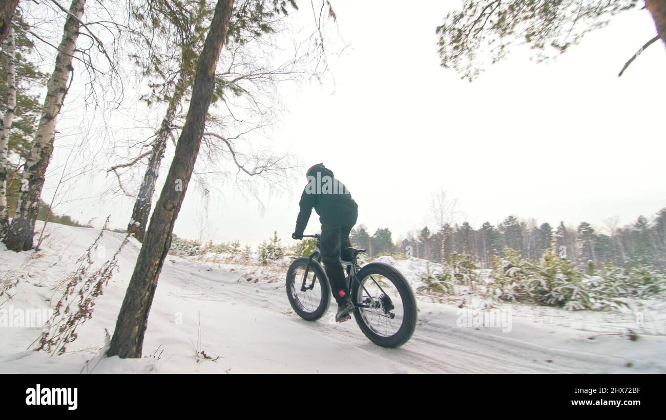 Professional extreme sportsman biker riding fat bike in outdoors ...