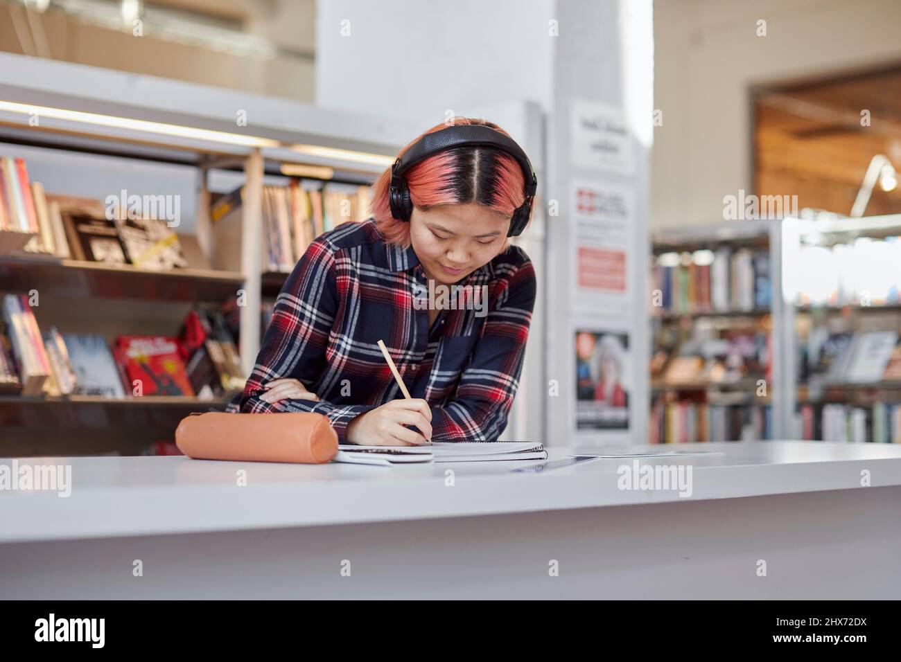 Female student taking notes in library Stock Photo - Alamy