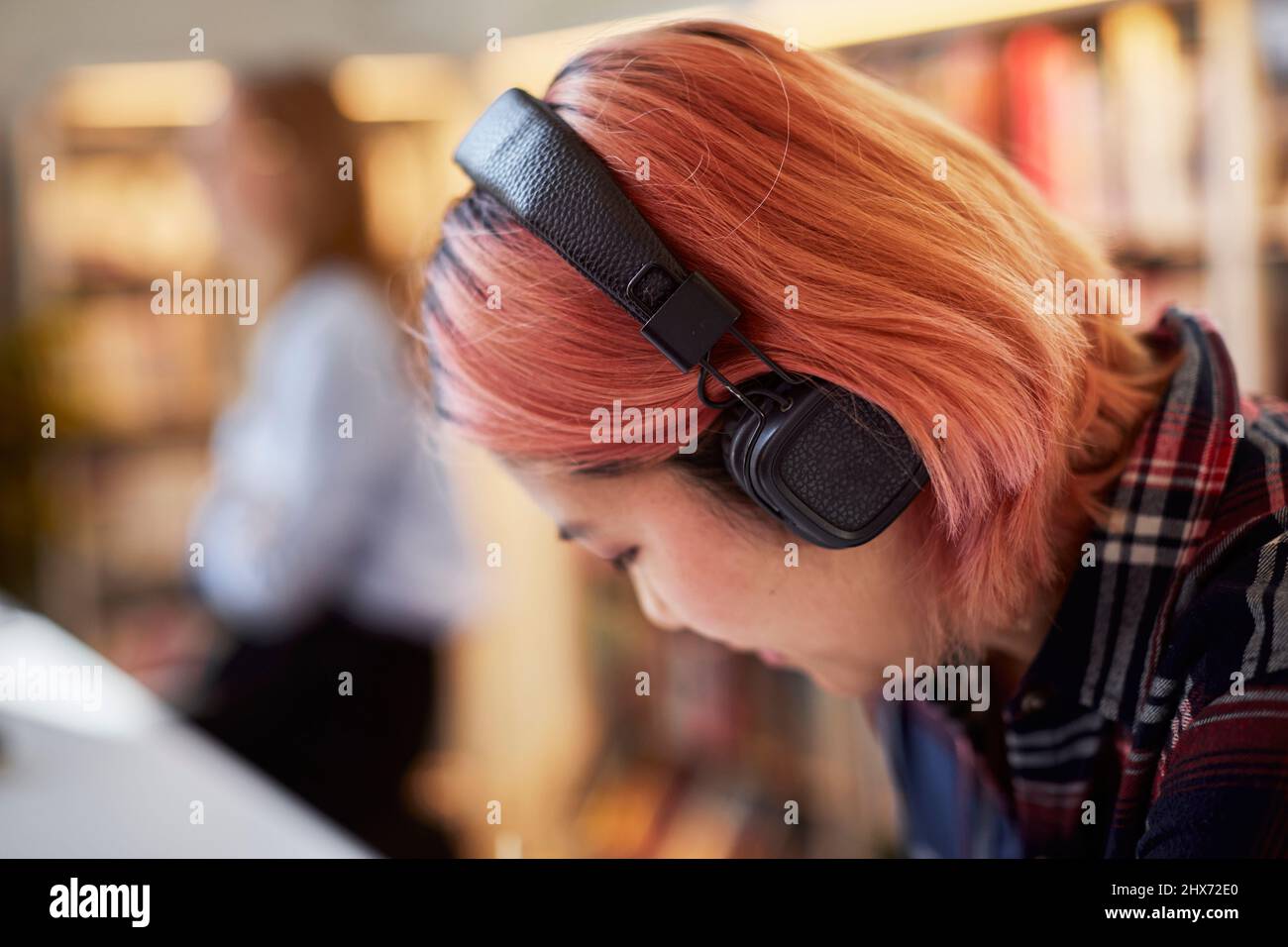 Female student listening to music in library Stock Photo - Alamy