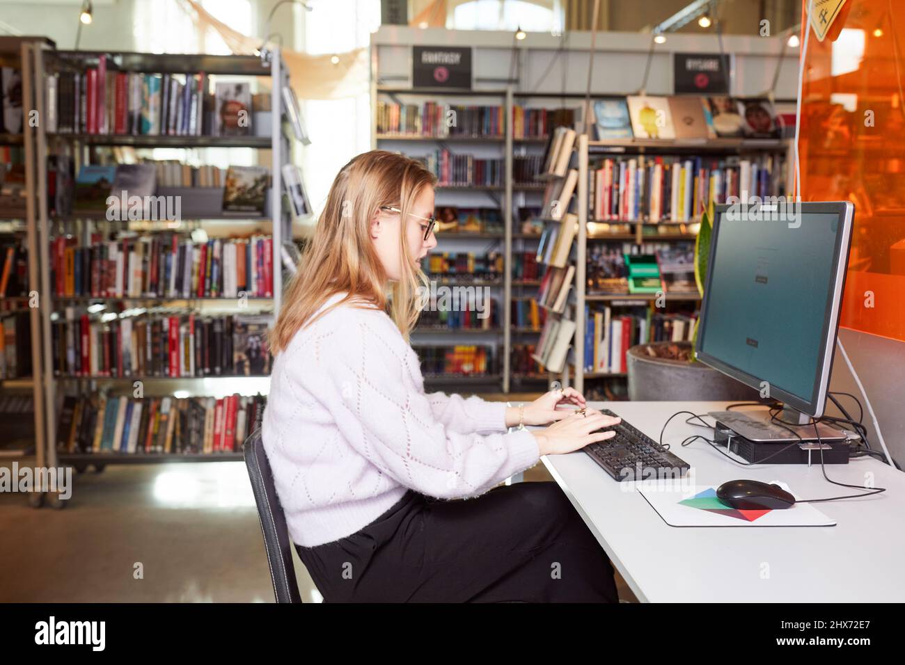 Female student using computer in library Stock Photo - Alamy