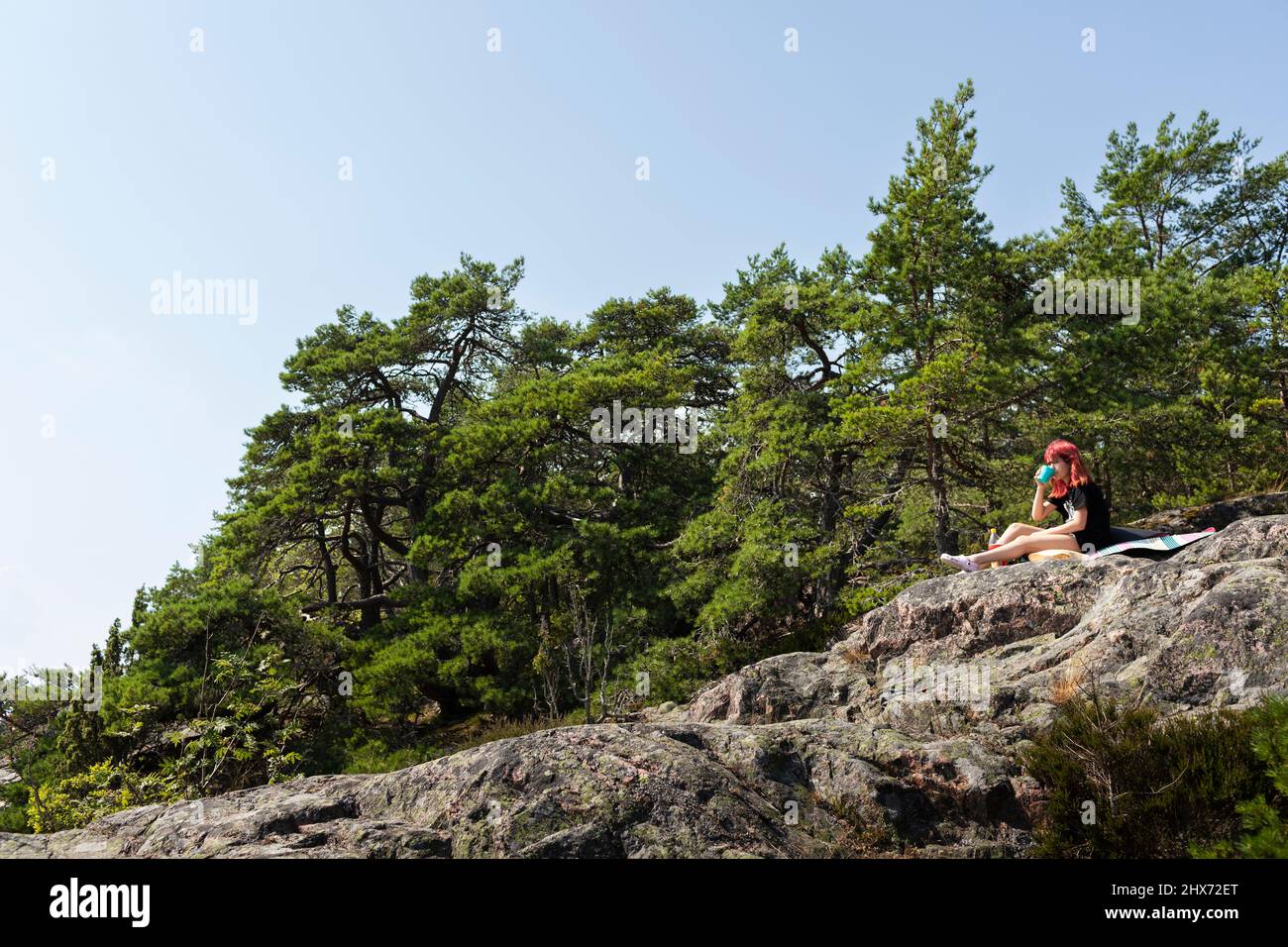 Woman relaxing on rocks Stock Photo - Alamy