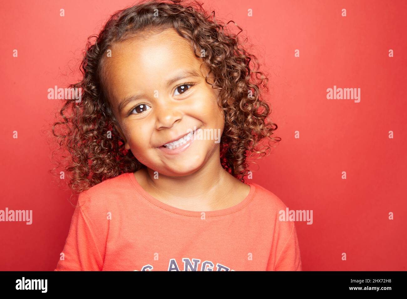 A little brown girl with brown hair, well-defined curls gesturing to ...