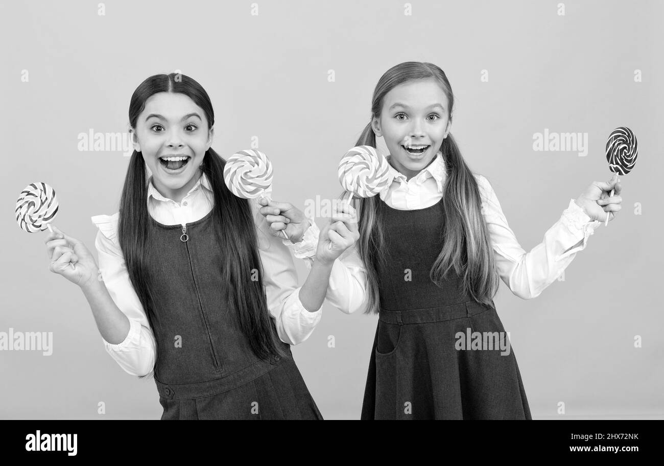 Happy kids in formal uniforms hold lollipops sweet treats yellow ...