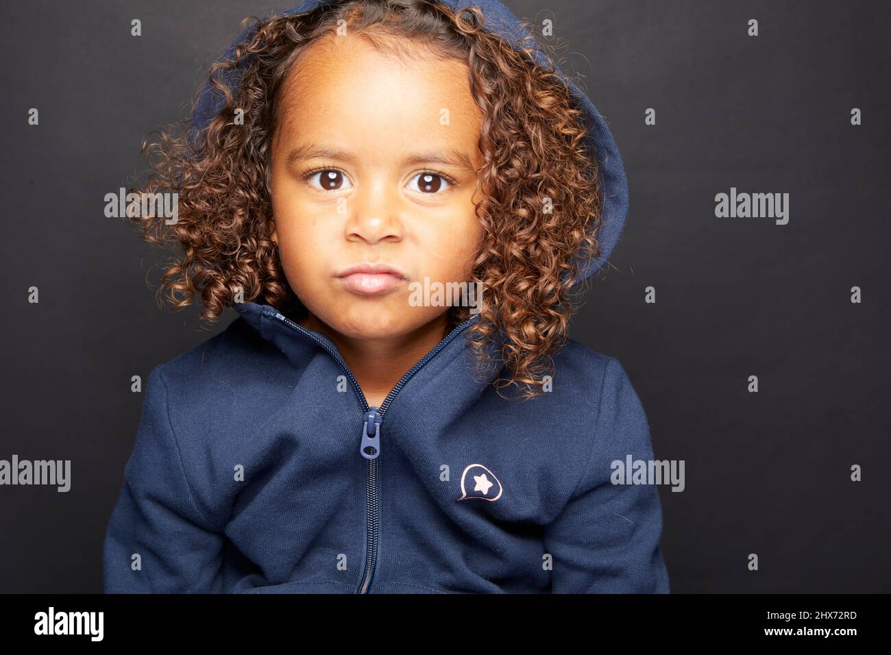 A little brown girl with brown hair, well-defined curls gesturing to ...