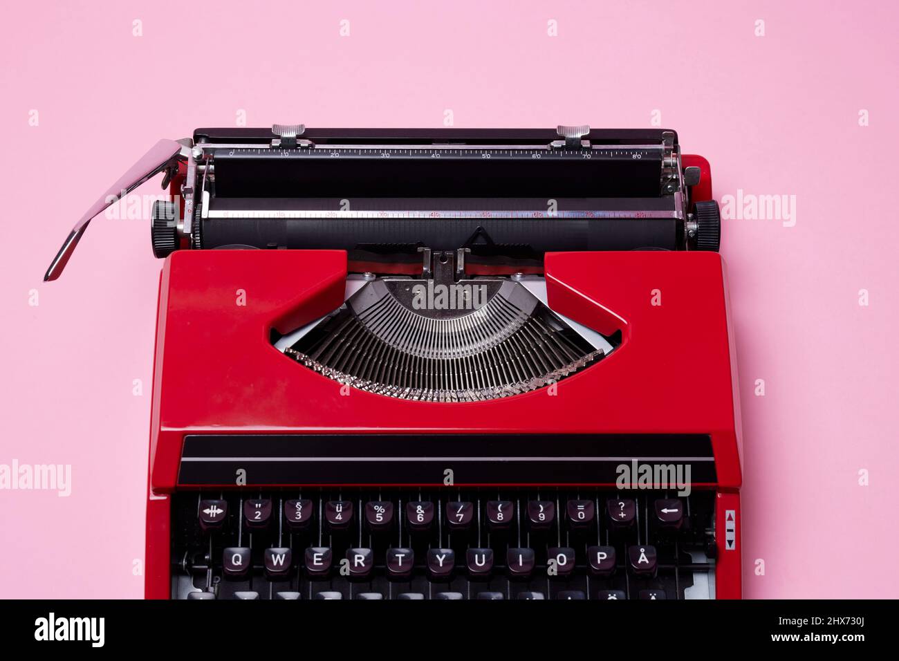 Red typewriter on pink background Stock Photo - Alamy