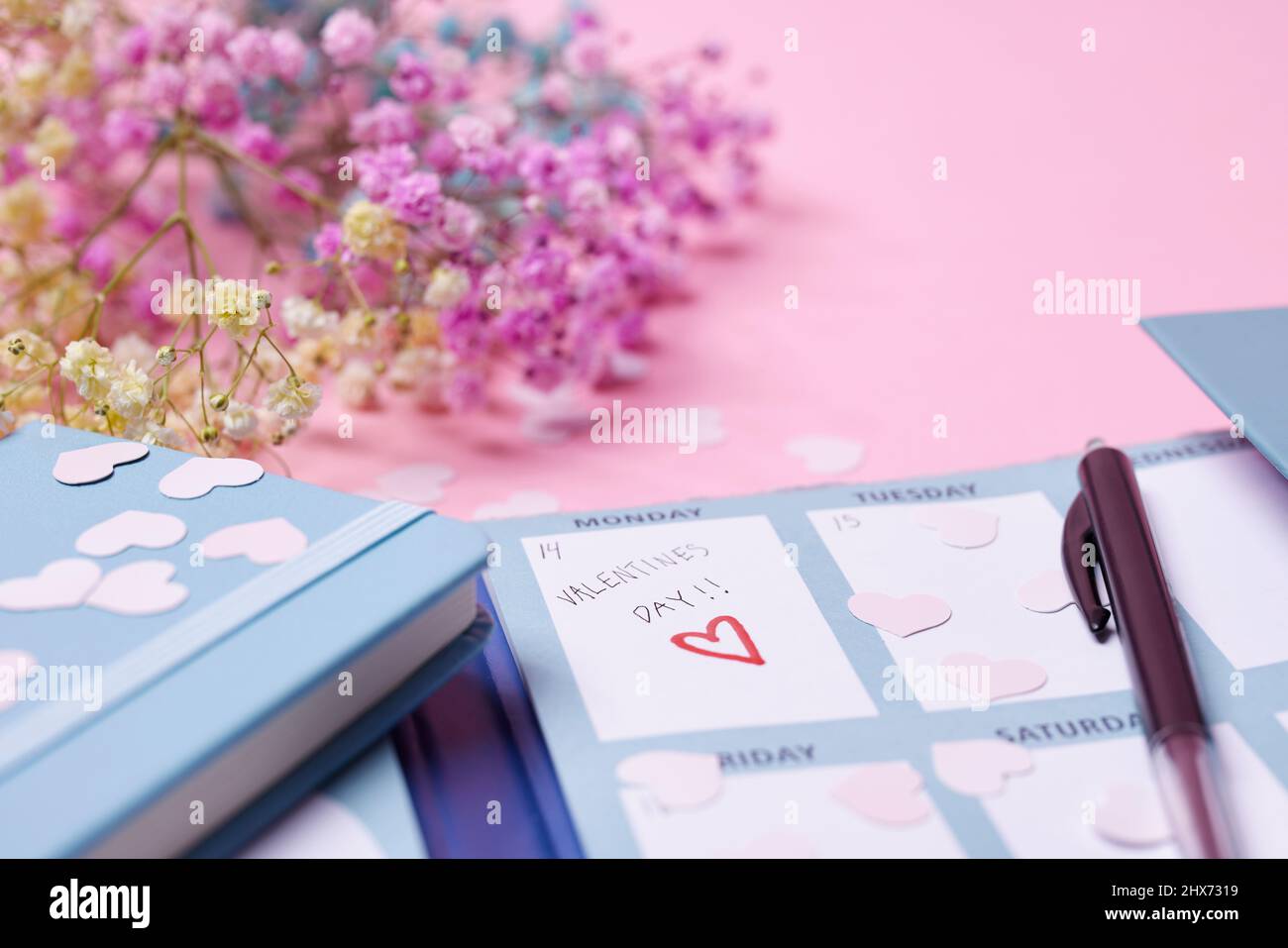 Heart-shaped confetti and calendar on pink background Stock Photo - Alamy